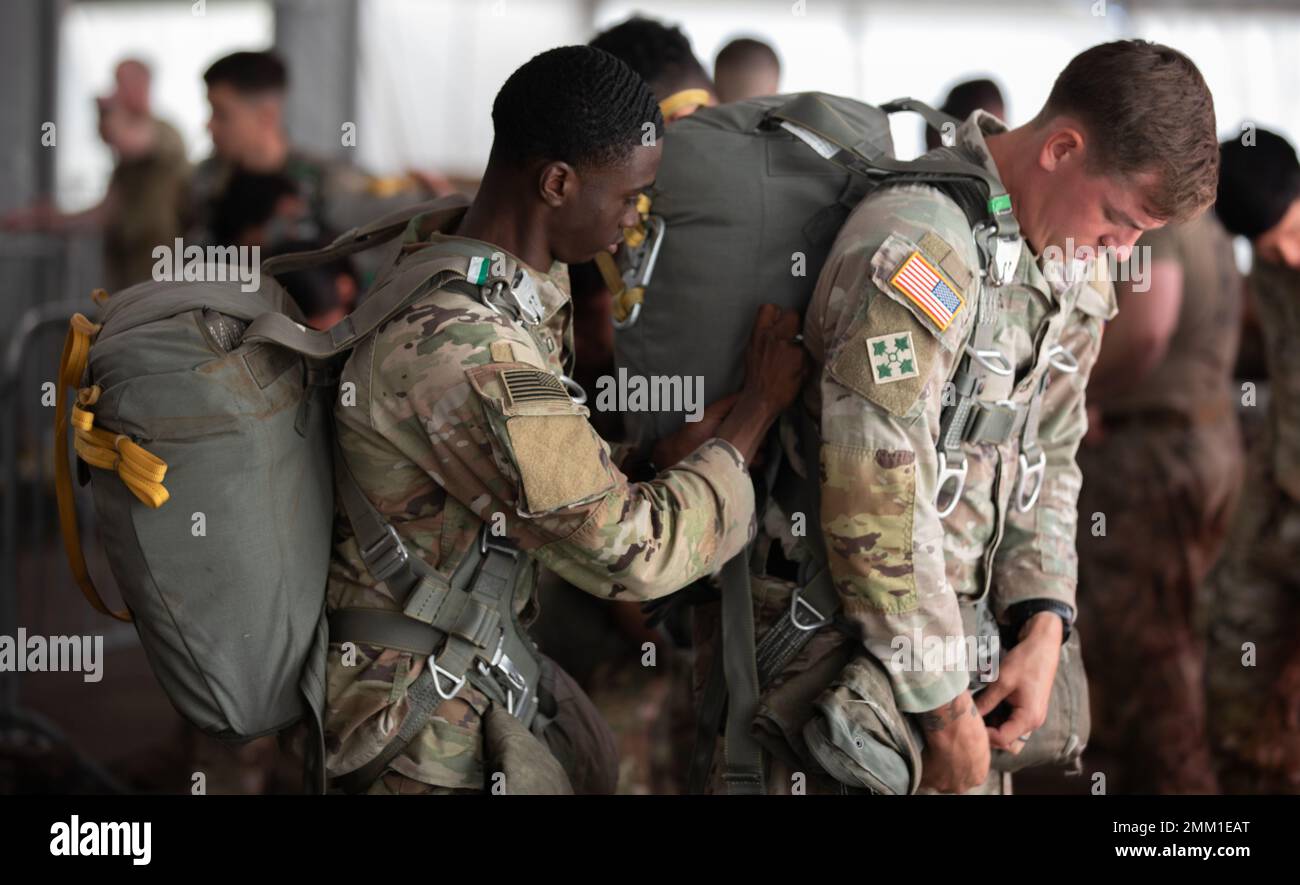 A group of U.S. Army Paratroopers help one another rig up into their T ...