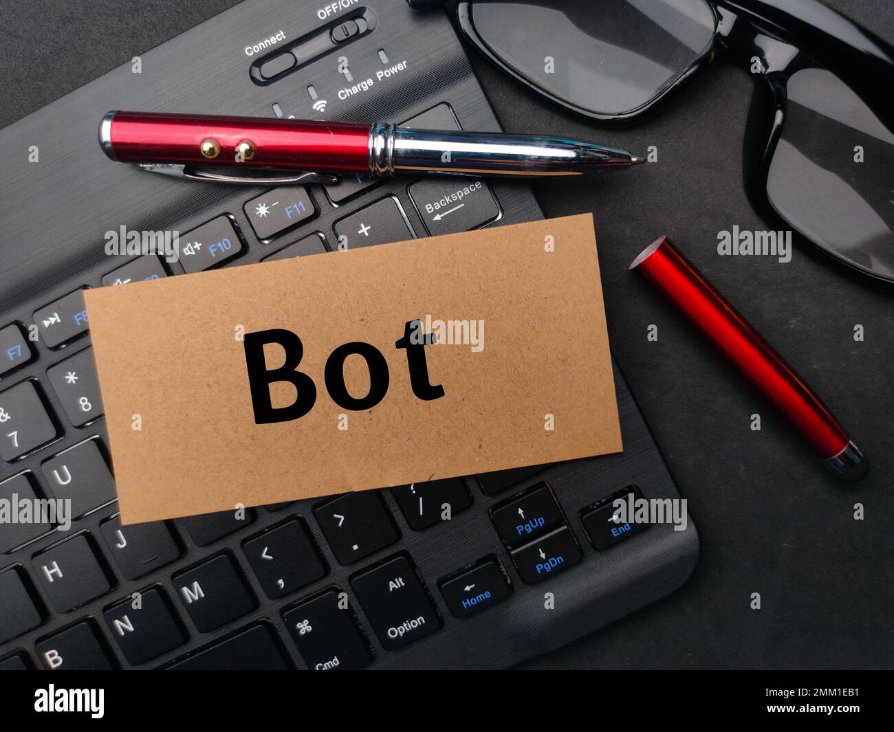 Keyboard and pen with the word BOT on black background Stock Photo - Alamy