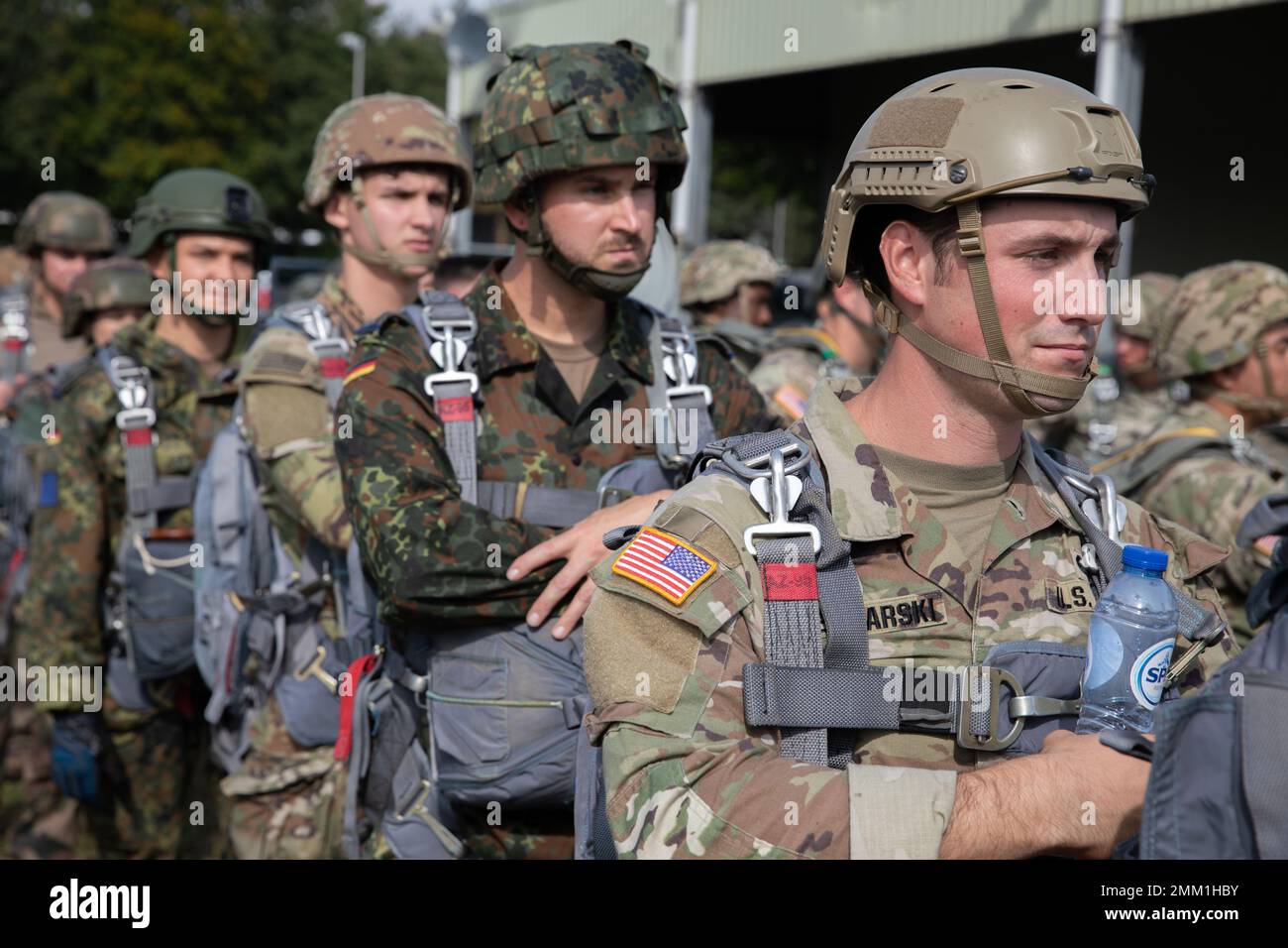 A group of U.S. Army Paratroopers, and European Paratroopers waits in ...