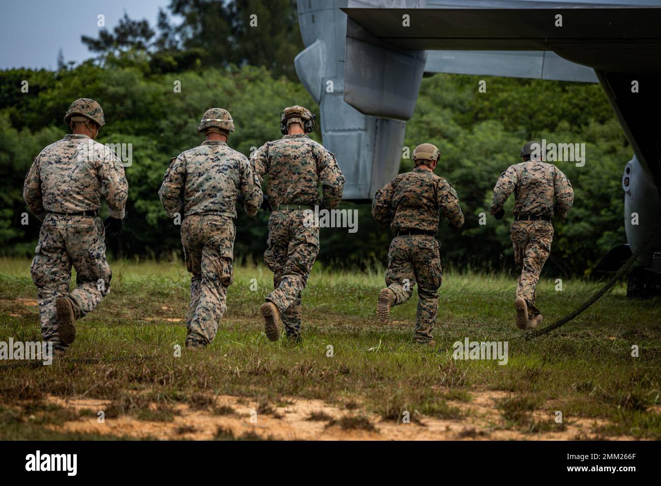 U.S. Marines with III Marine Expeditionary Force (MEF) run towards an ...