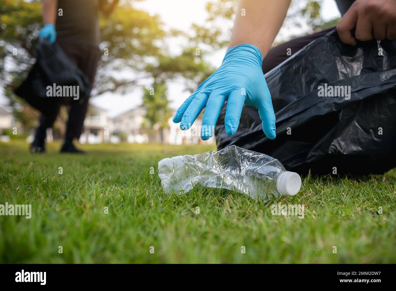 Volunteer man collecting trash and reusing plastic cleanup to recycle ...