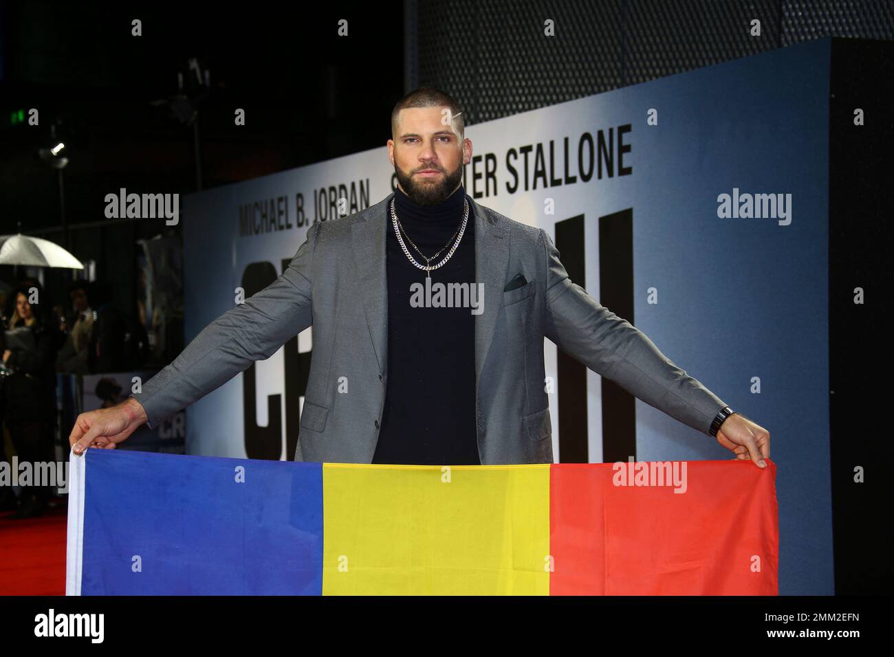 Actor Florian Munteanu poses for photographers with the flag of Romania ...