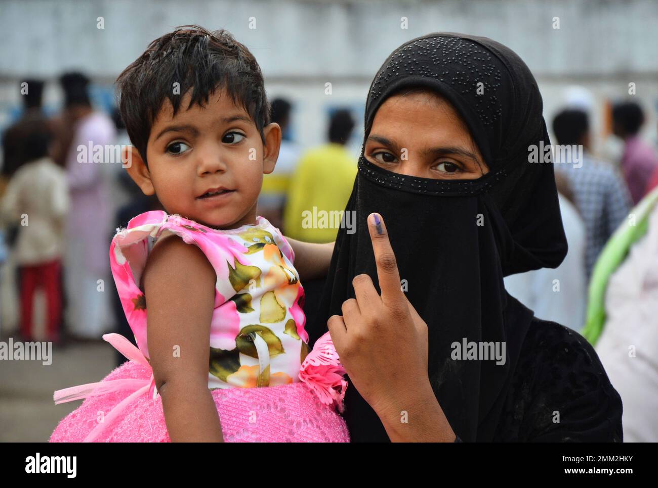 Parveen Bano carries her 3-year-old daughter Haazra and displays the ...