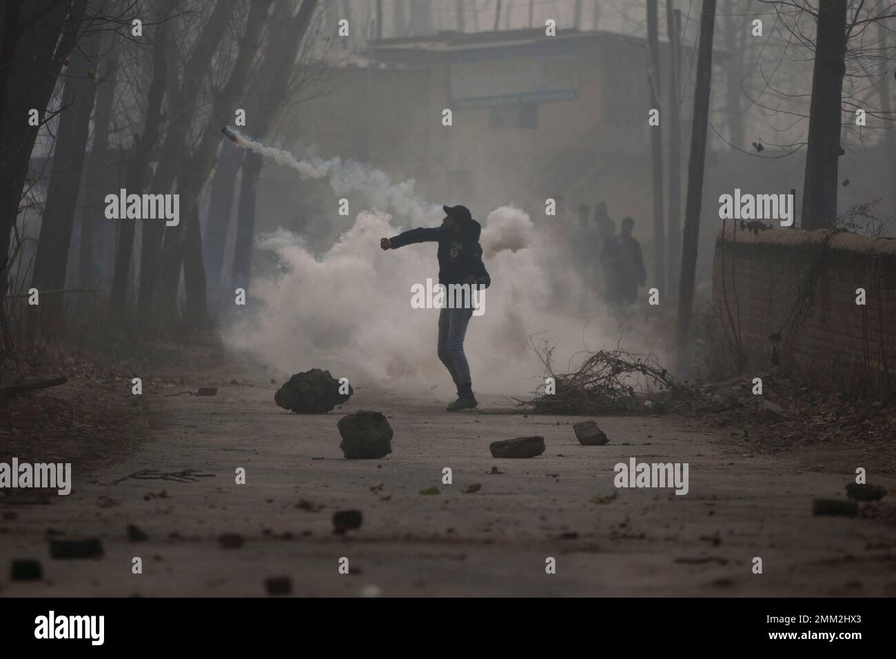 A Kashmiri protester throws exploded shell back at Indian police men as ...