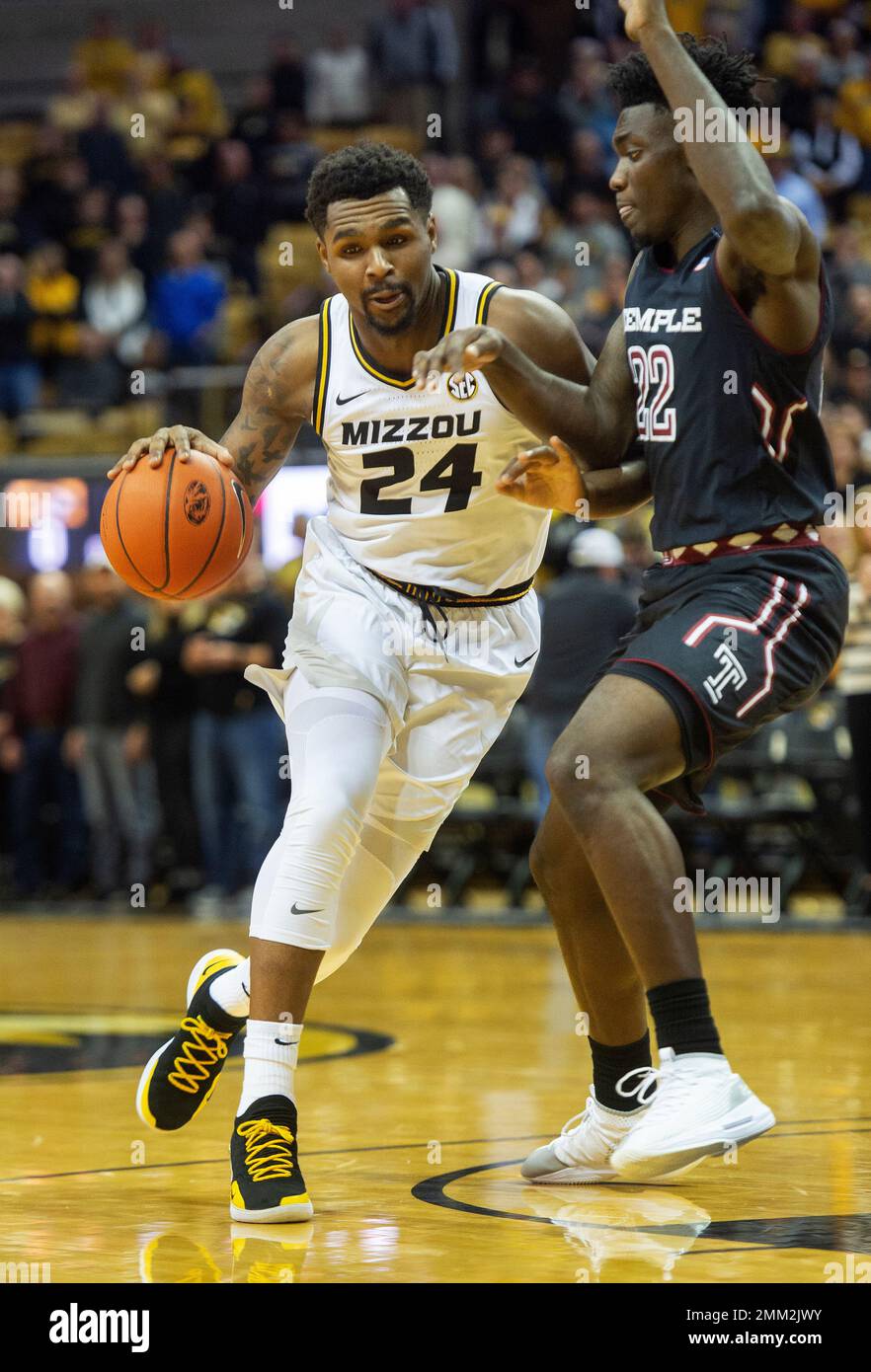 Missouri's Kevin Puryear, left, dribbles past Temple's De'Vondre Perry ...