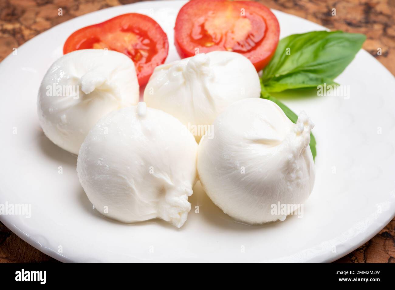 Eating of fresh handmade soft Italian cheese from Puglia, white balls ...