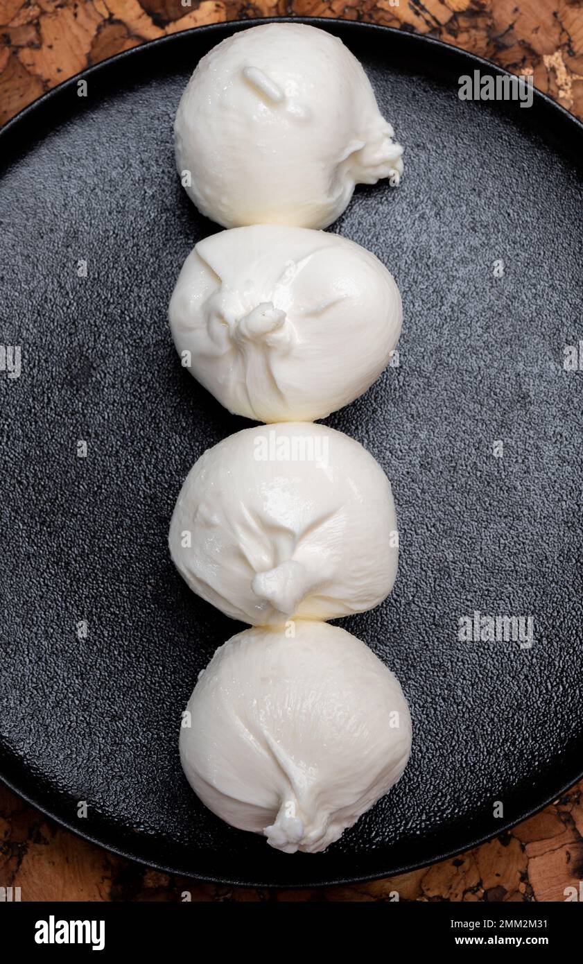 Eating of fresh handmade soft Italian cheese from Puglia, white balls ...