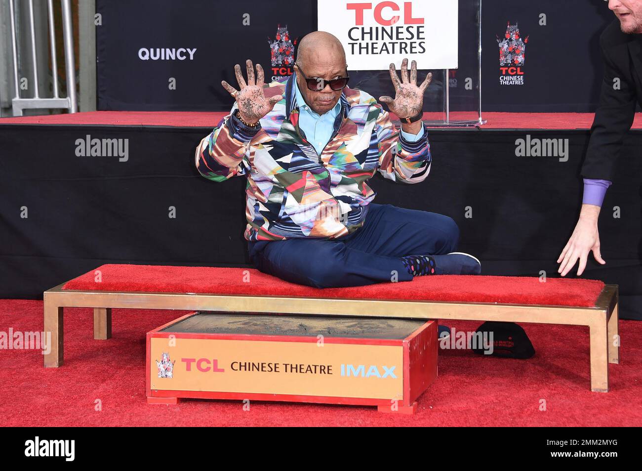 Quincy Jones poses for photos after placing his hands in wet cement ...