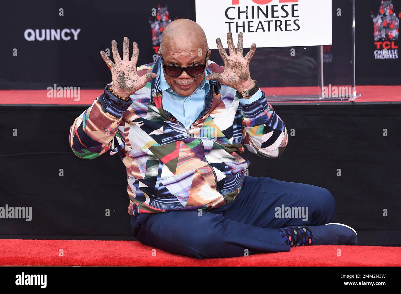 Quincy Jones poses for photos after placing his hands in wet cement ...