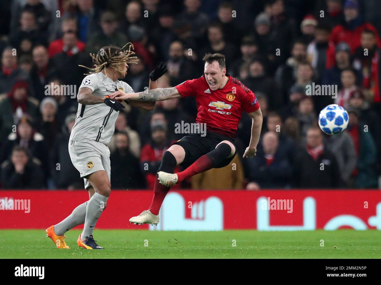 ManU defender Phil Jones, right, fights for the ball with Young Boys ...