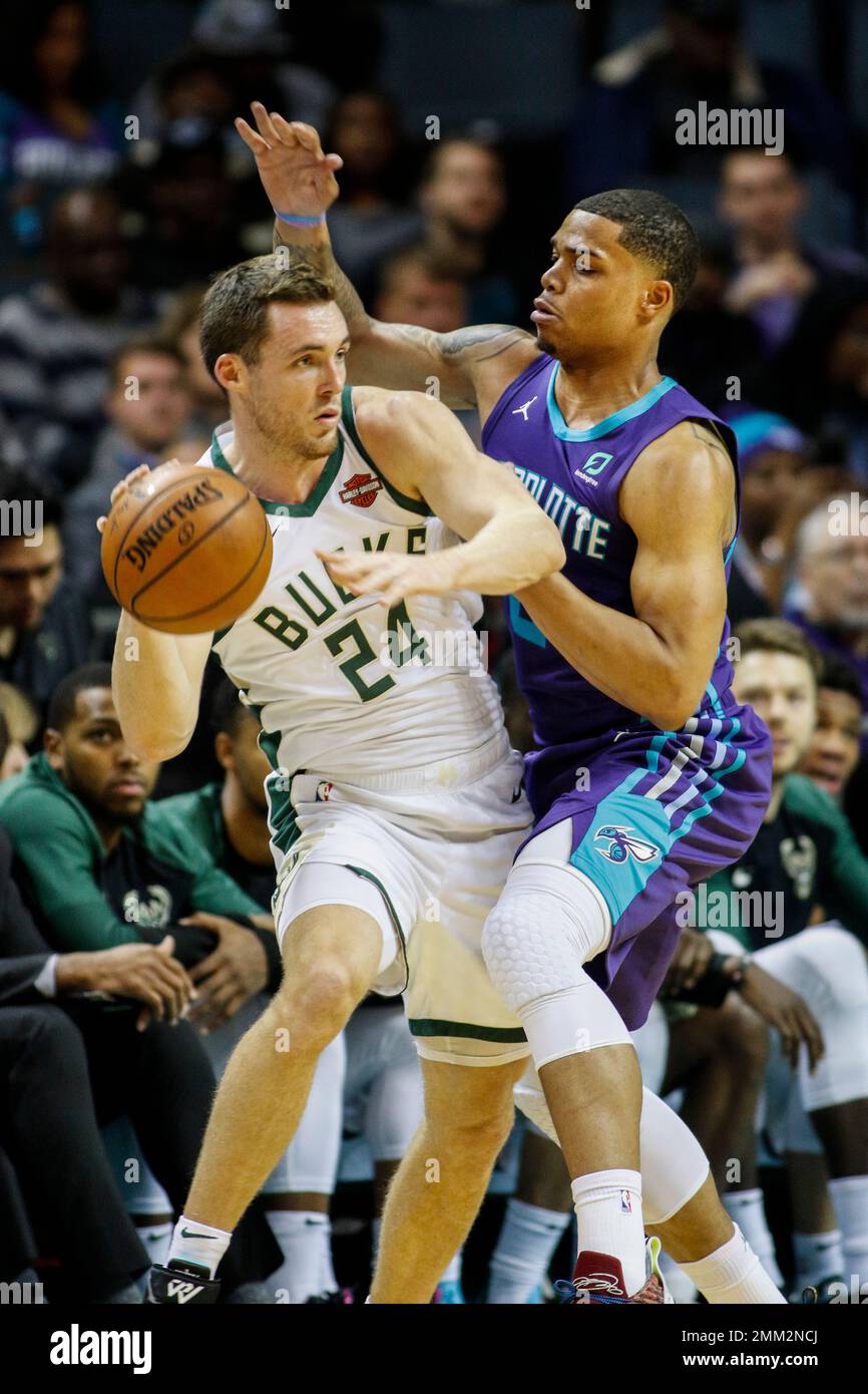 Milwaukee Bucks guard Pat Connaughton, left, looks to pass around ...