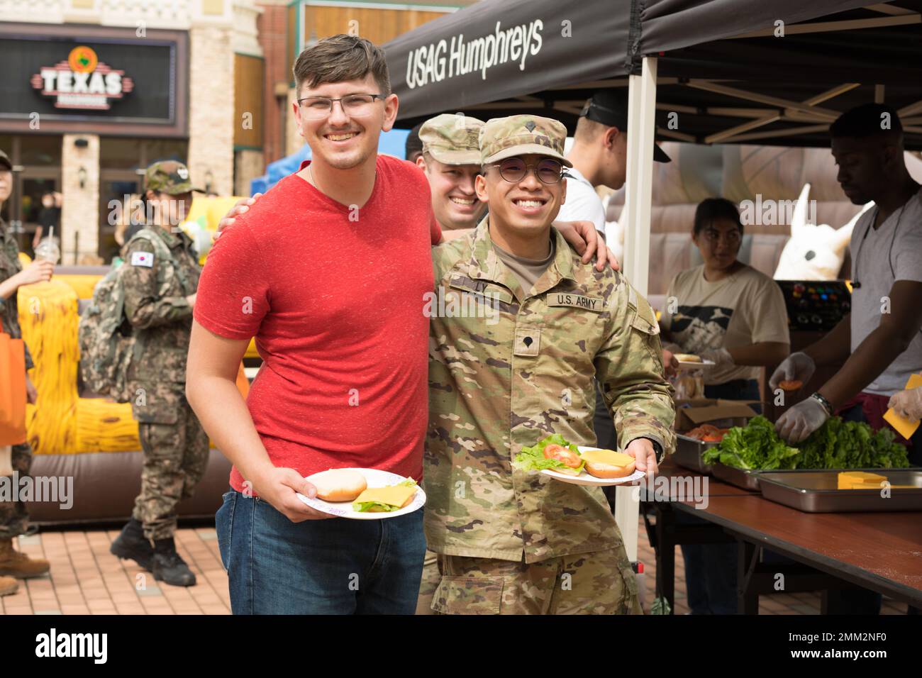 Members of the USAG Humphreys community enjoy free hamburgers cooked by ...