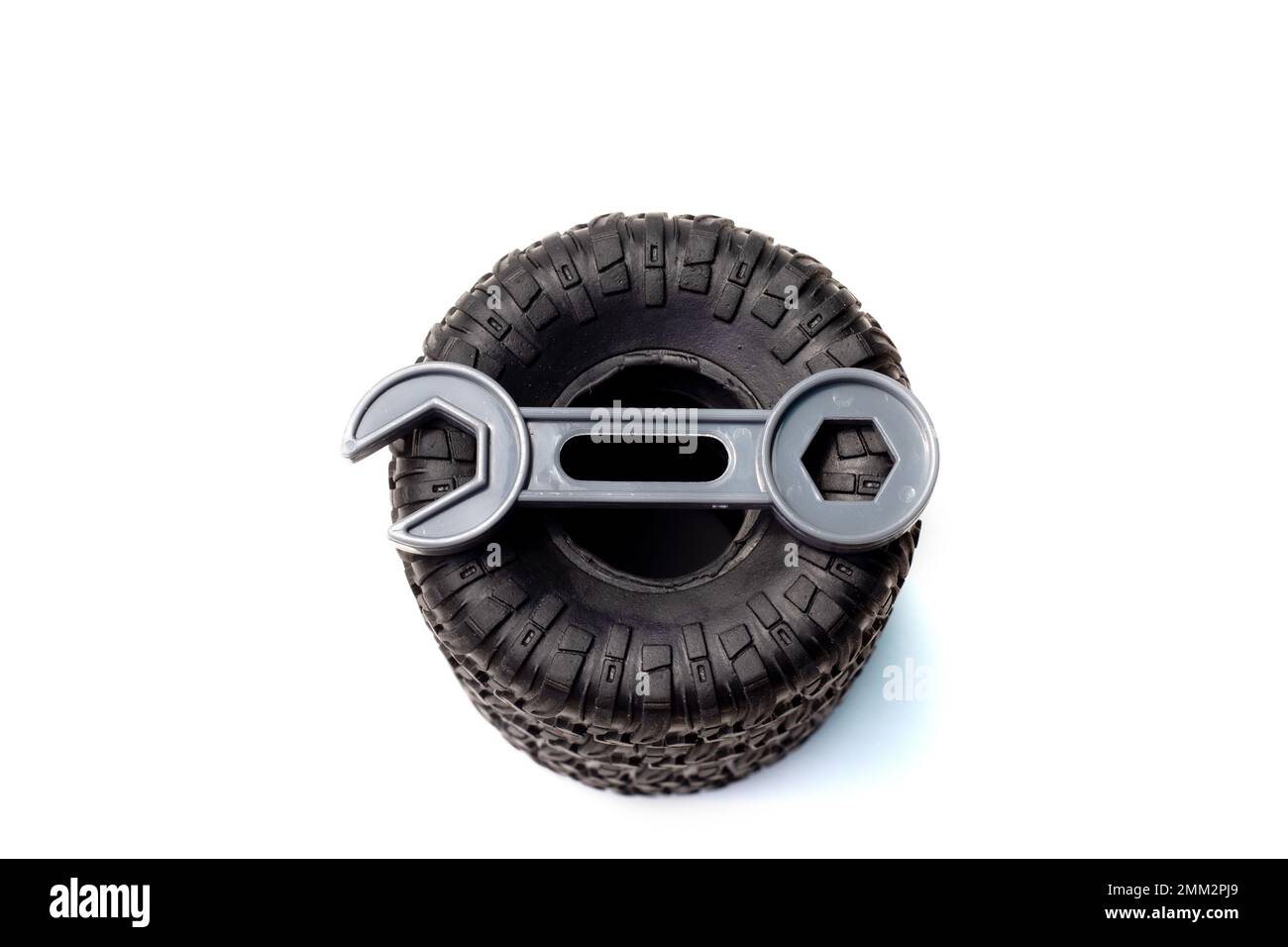 black rubber tire from toy car and plastic gray wrench key isolated ...