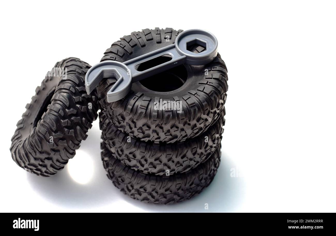 black rubber tire from toy car and plastic gray wrench key isolated ...