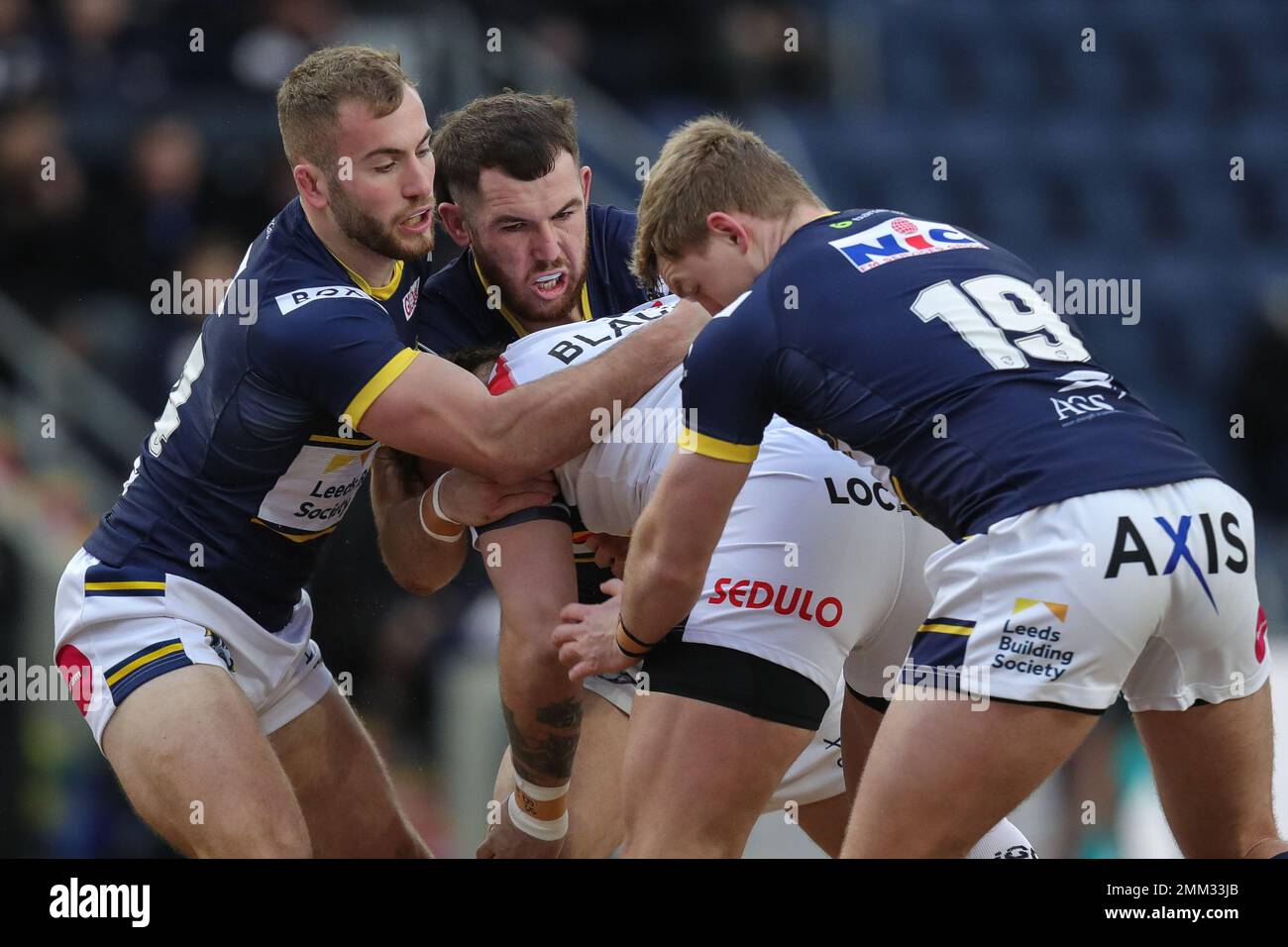 Jarrod O’Connor #14 and Cameron Smith #13 of Leeds Rhinos tackle Ben ...
