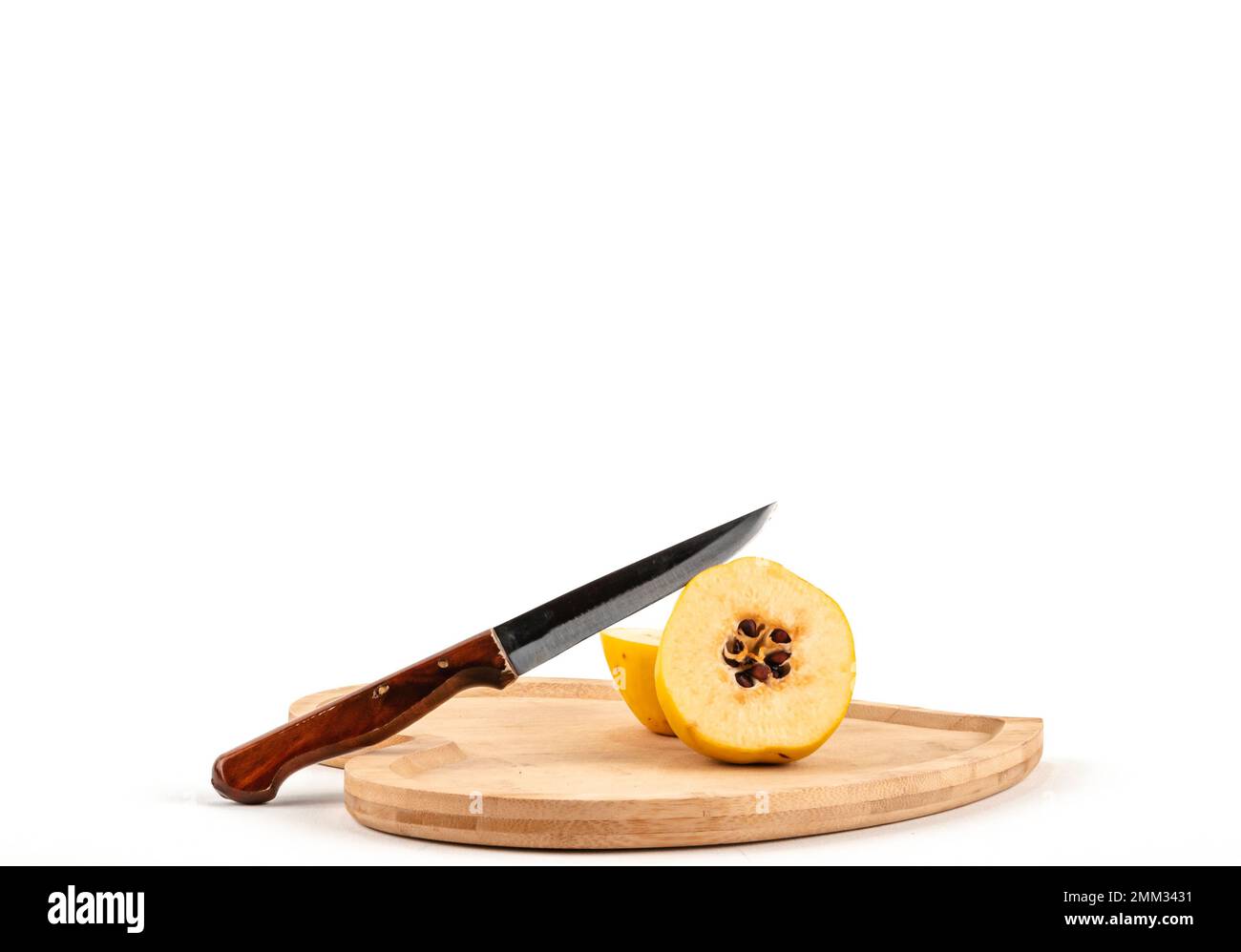 Quince cutted with knife from half seeds appear on wooden cutting board ...