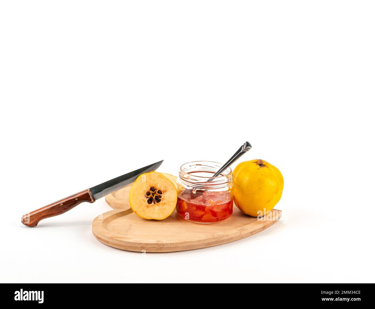 Camera view spoon and knife cutting Fresh ripe quince and jam on white ...
