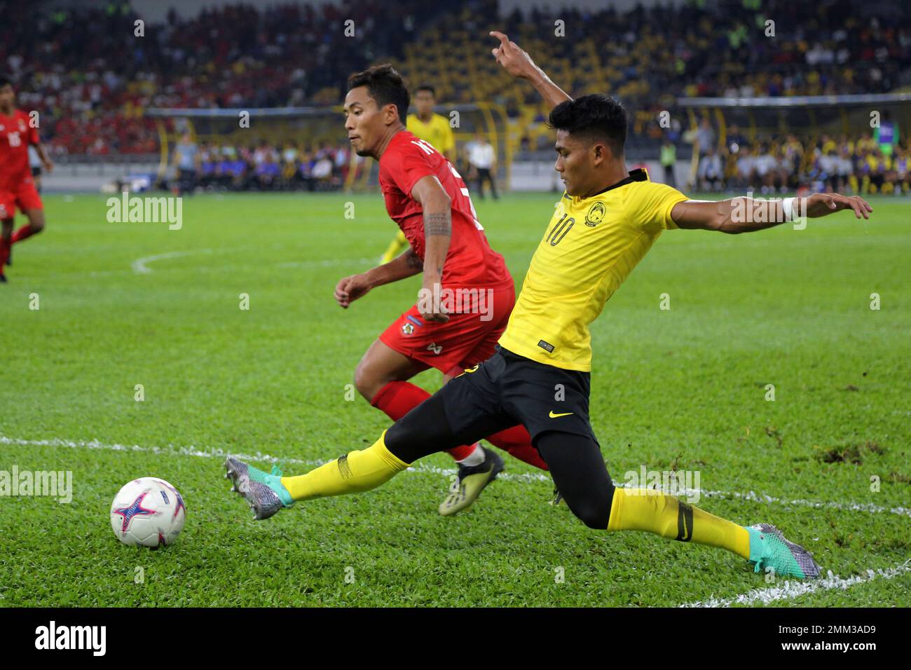 Malaysia's Muhammad Shahrel Fikri Md Fauzi, left, battles for the ball with Myanmar Ye Ko Oo ...