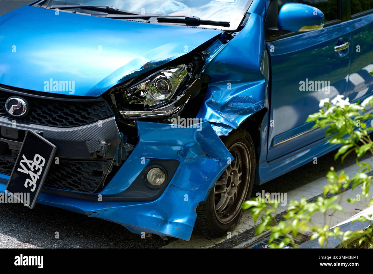 A blue car with a broken headlight and a dented front fender. Kuala ...