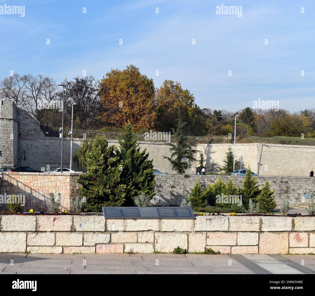 View on a part of quay with stone fence and bushes. Blue sky and ...