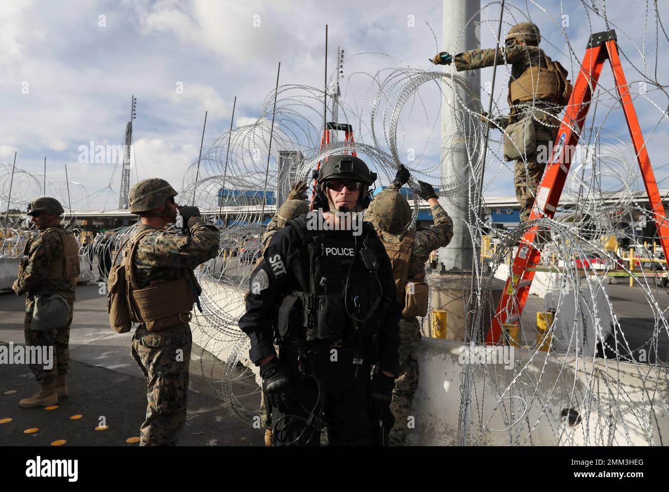 U.S. soldiers set up concertina wire as a customs and border protection ...