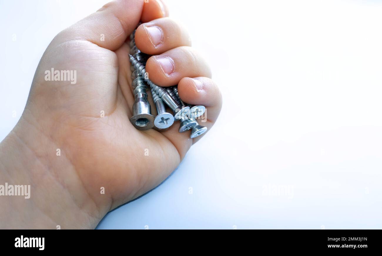 screw different sizes in a row or kid hand chaotic Stock Photo - Alamy