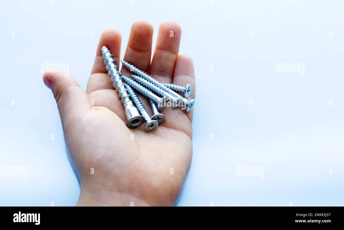 screw different sizes in a row or kid hand chaotic Stock Photo - Alamy