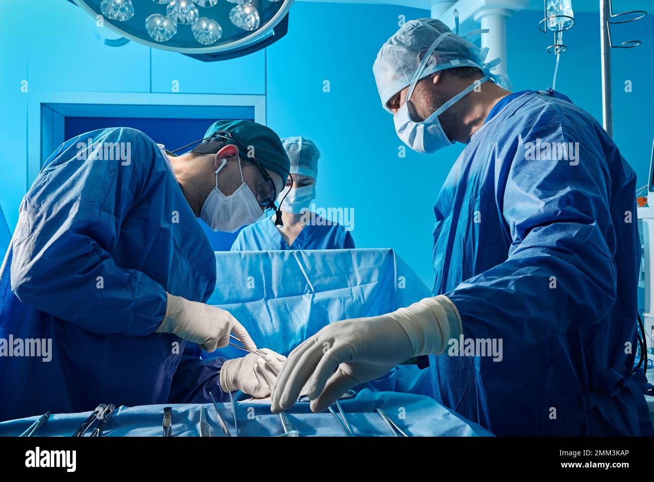 Two surgeons performing operating on patient in hospital's operating ...