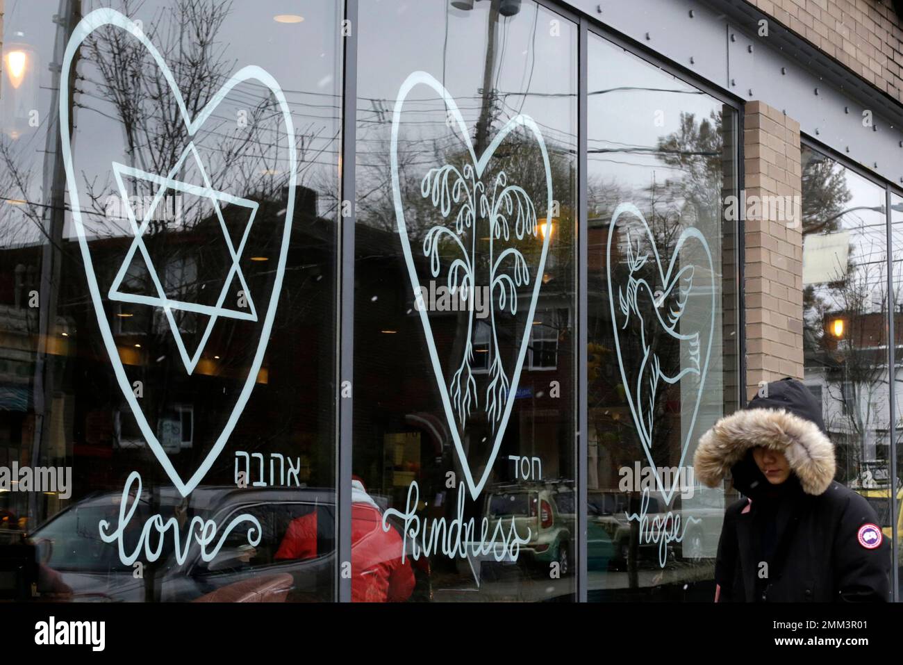 In this Tuesday, Nov. 20, 2018 photo, a woman walks past the window of ...