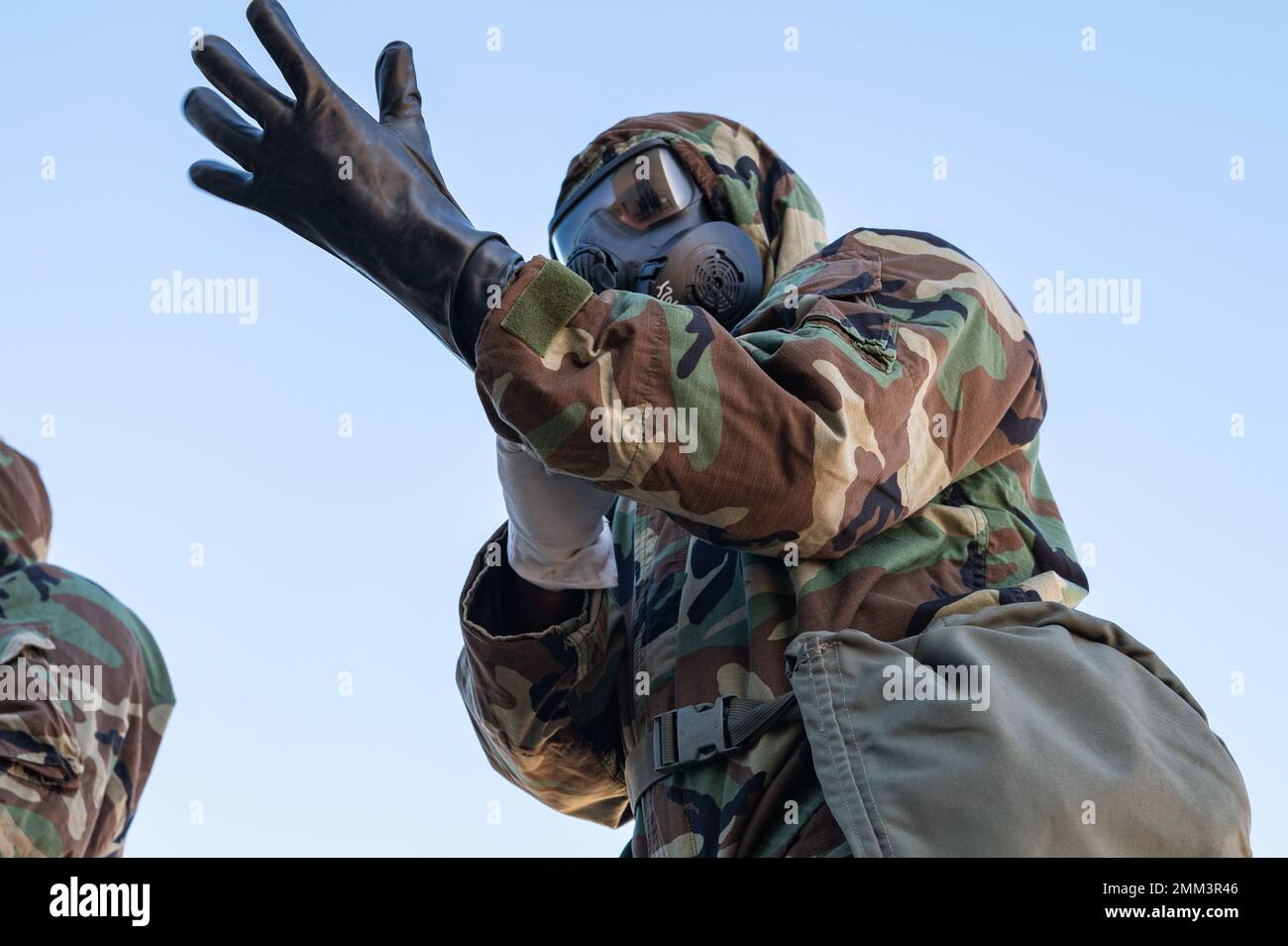 An Airman puts on a component of Mission Oriented Protective Posture ...