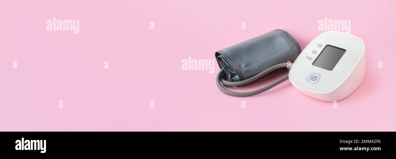 Automatic blood pressure monitor on pink background banner. Medical ...