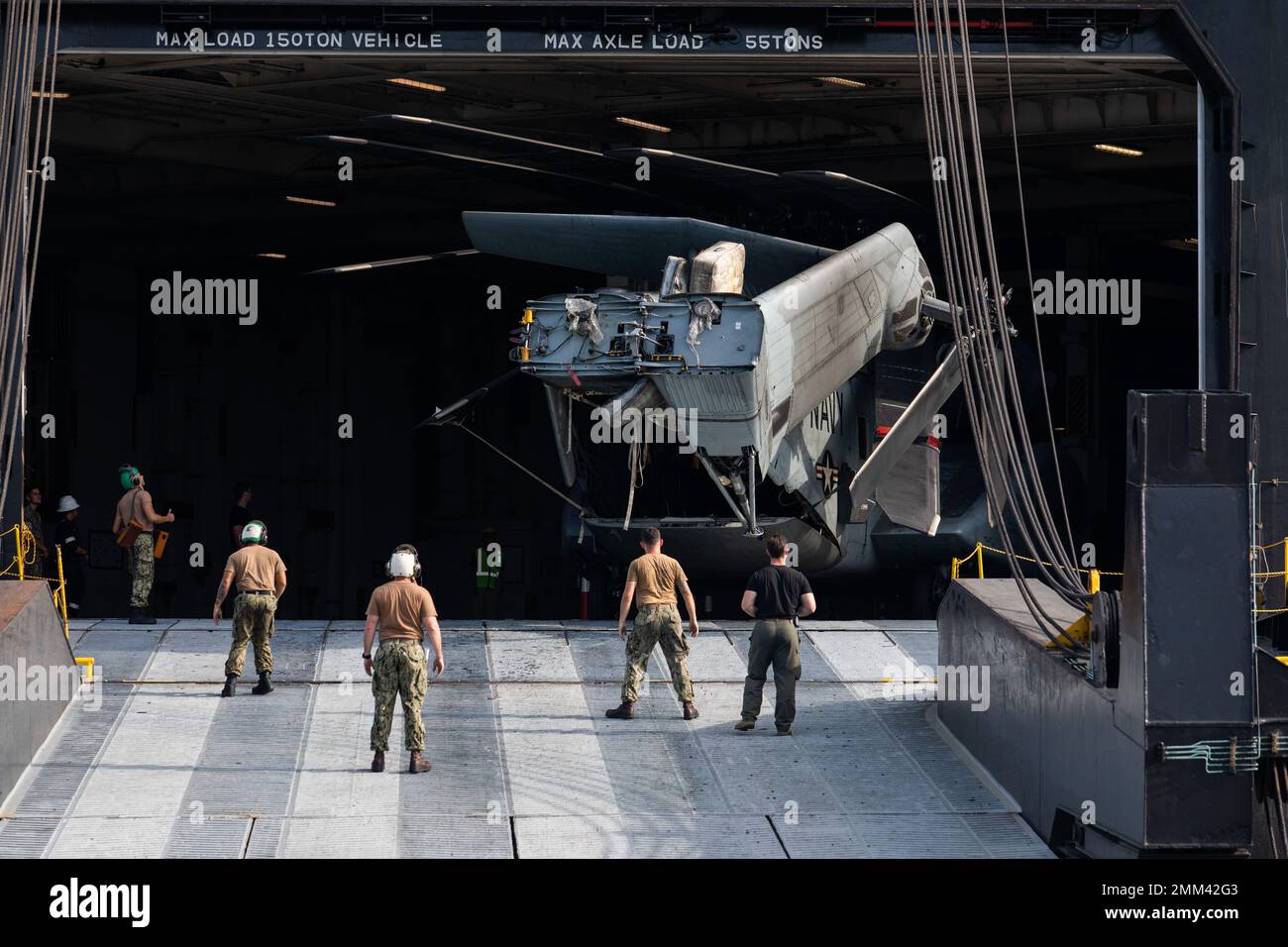 U.S. Navy Sailors with Helicopter Mine Countermeasures Squadron 14 offload an MH-53 Sea Dragon ...