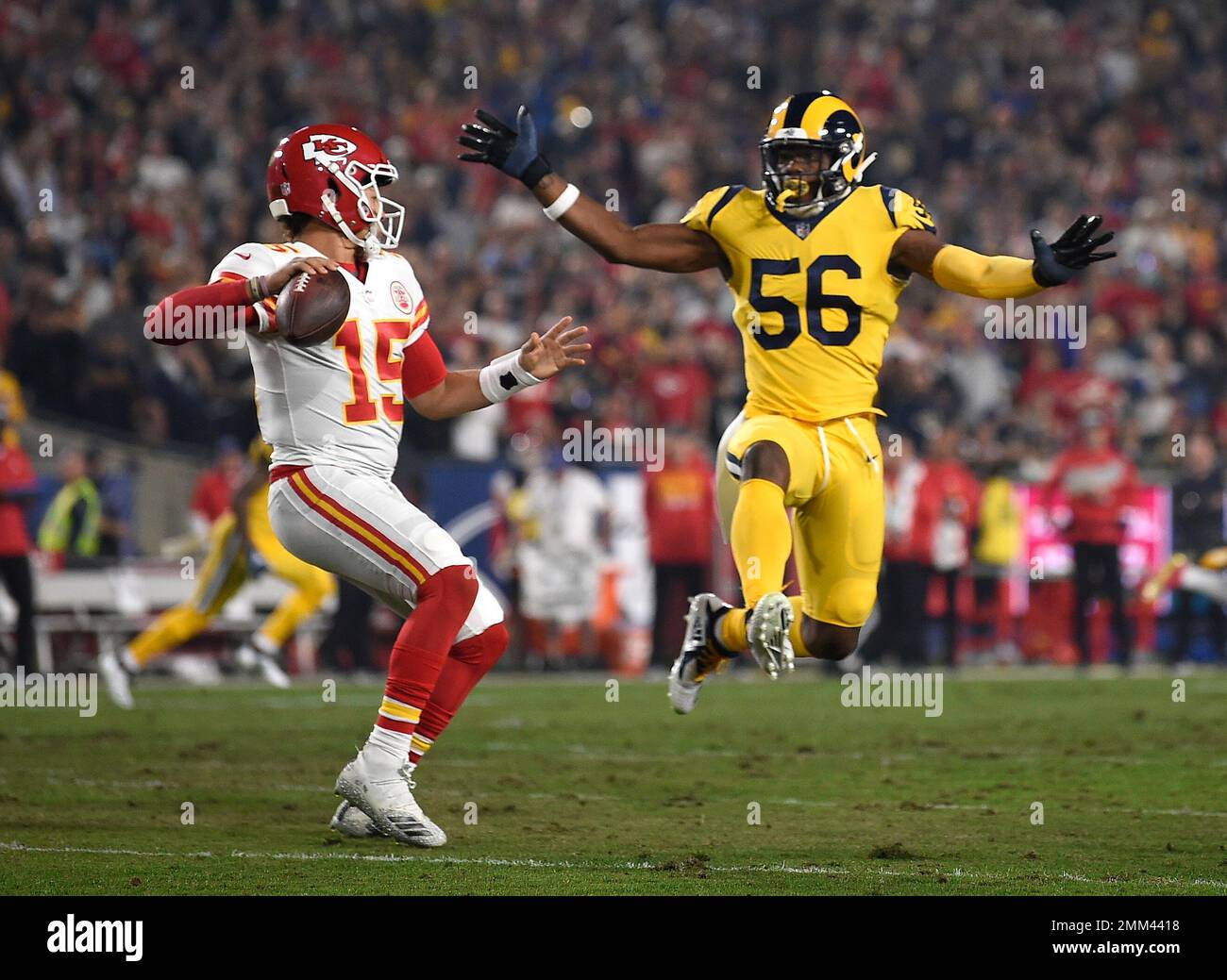 Kansas City Chiefs quarterback Patrick Mahomes, left, passes under ...