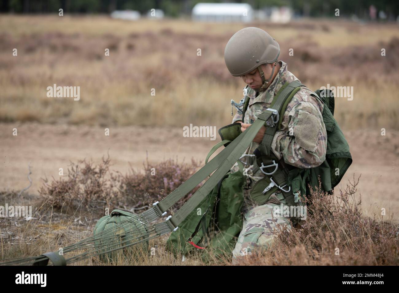 A U.S. Army Paratrooper derigs his German T-10 parachute after landing ...