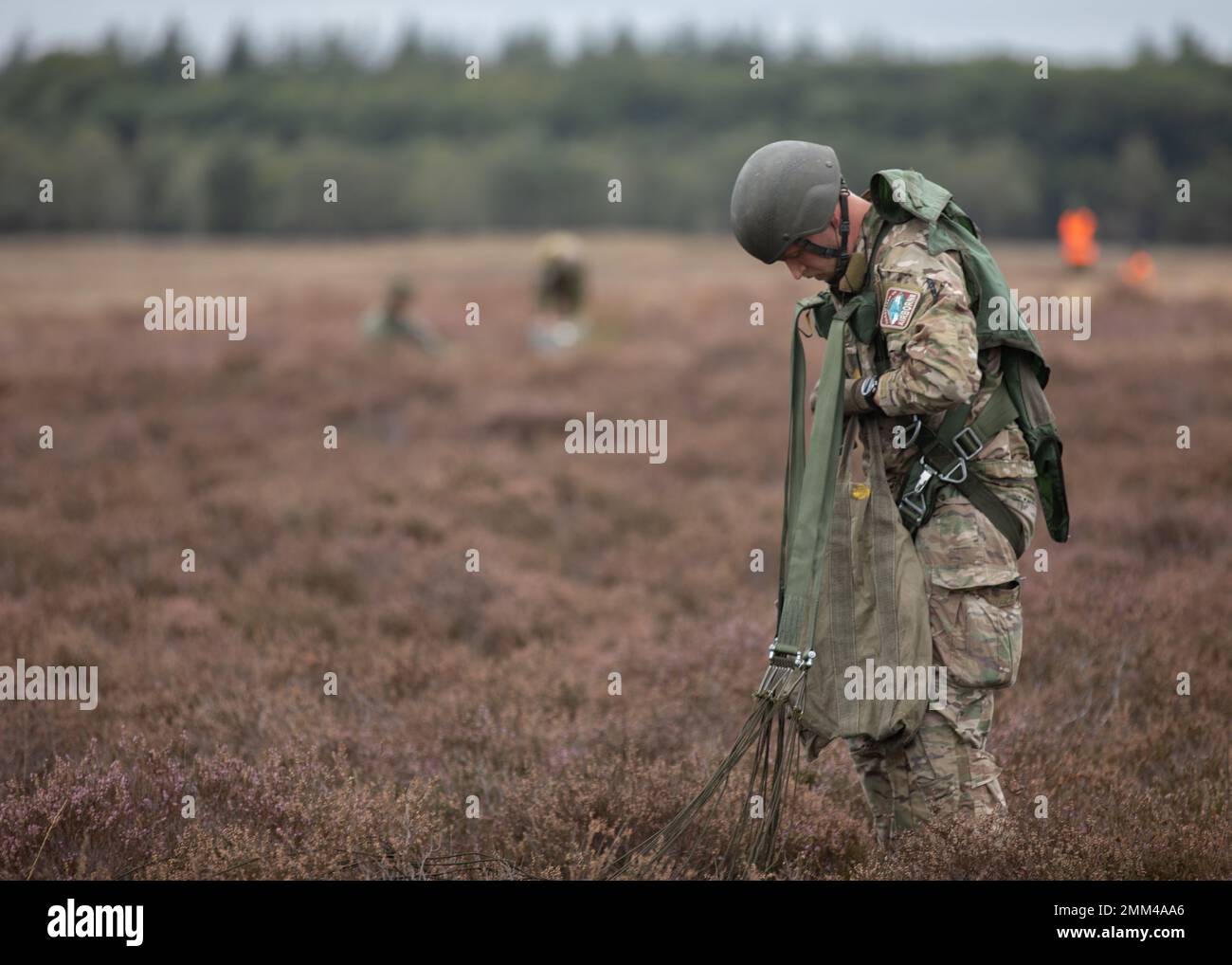 A Dutch Paratrooper packs away his German T-10 parachute after landing ...