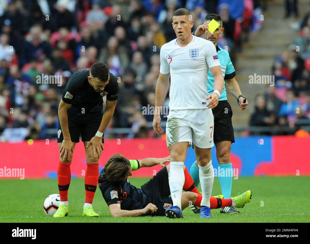 Referee Tasos Sidiropoulos shows a yellow card to England's Ross ...