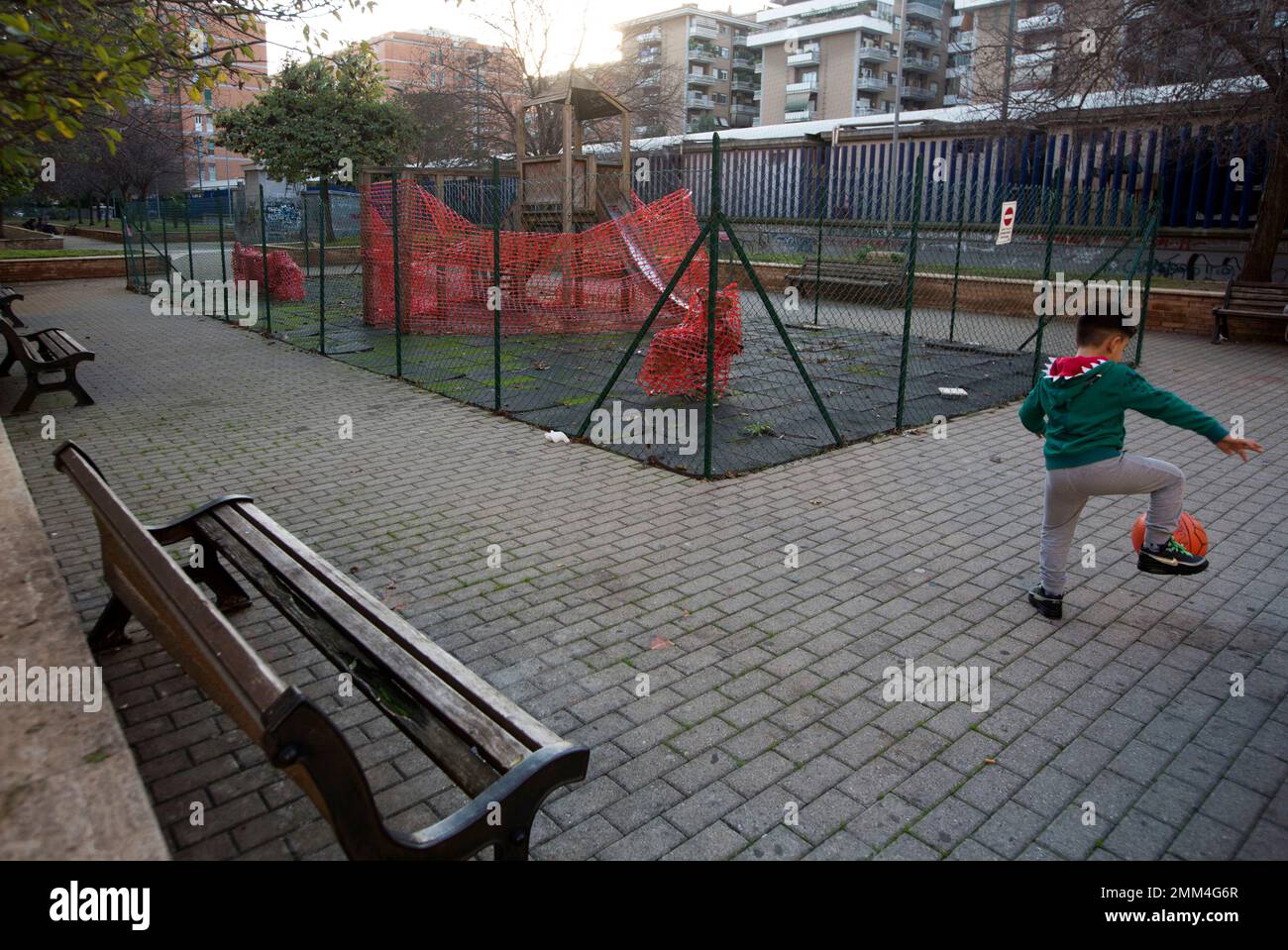 A child plays in front of a closed rundown playground in Rome's ...