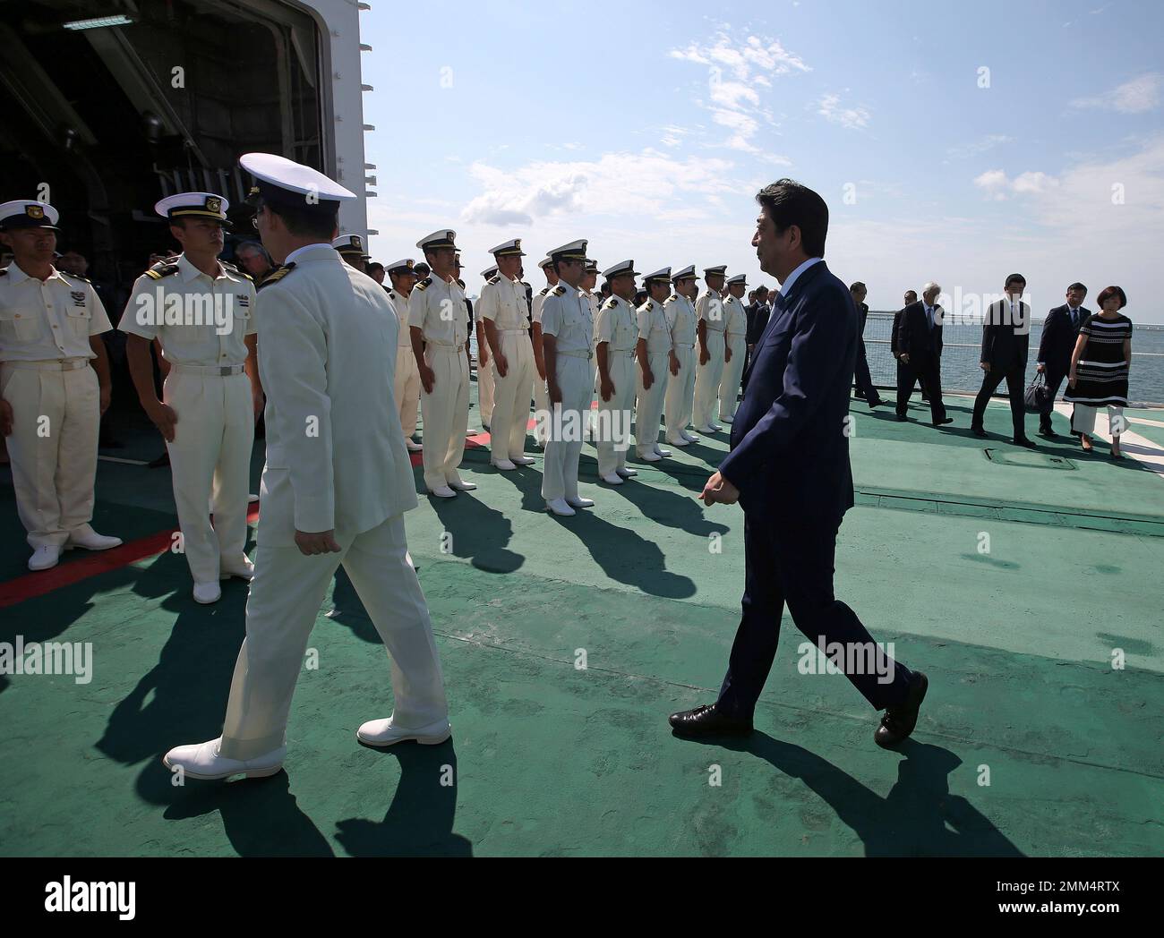 Japan's Prime Minister Shinzo Abe, center, walks past sailors while he ...