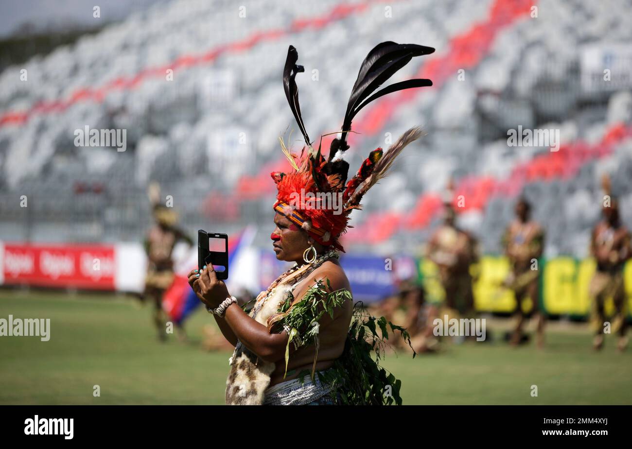 A dancer wearing a traditional costume uses her smartphone to record a ...