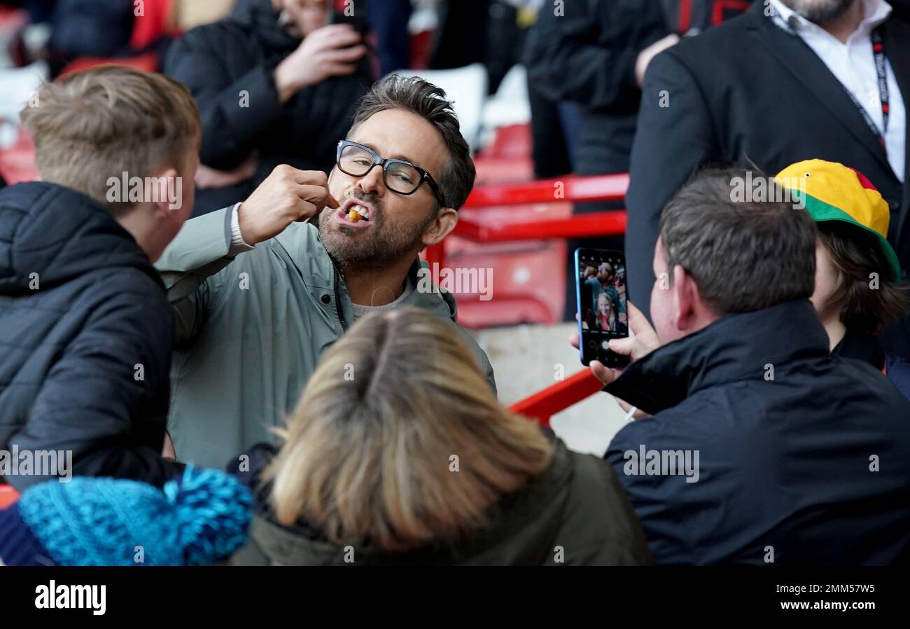 Wrexham co-owner Ryan Reynolds eats a chip given to him by a fan before ...