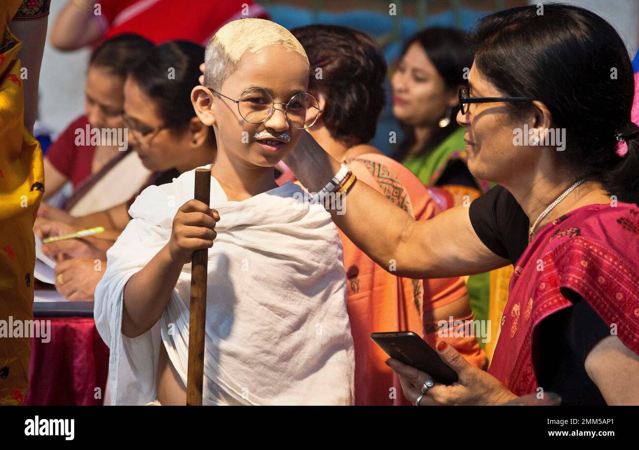 A child, dressed as Mahatma Gandhi waits to perform during an event to ...