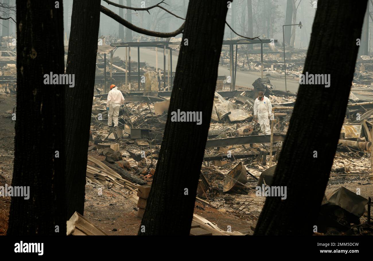 A search and rescue workers search for human remains at a burned out ...