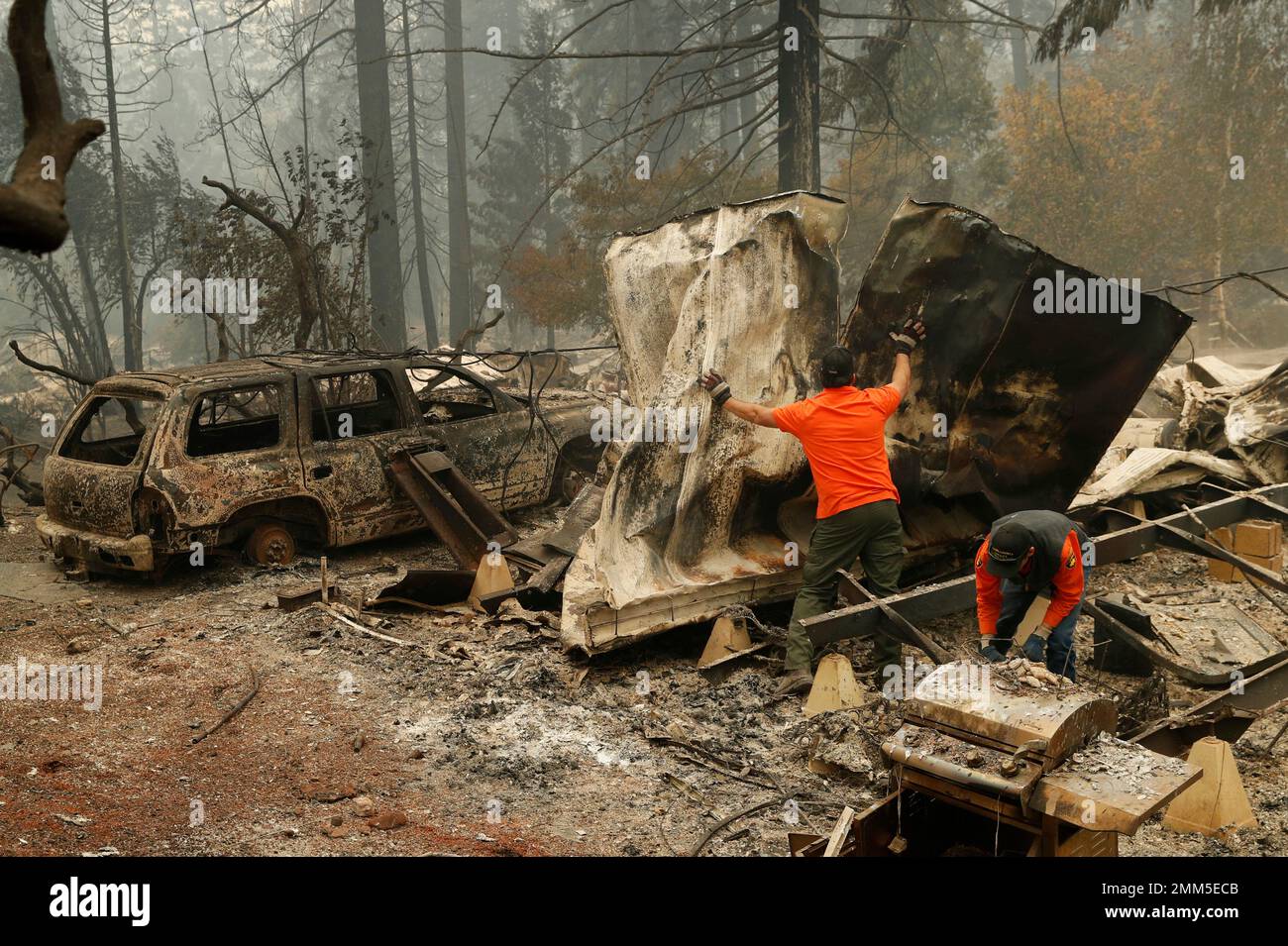 Search and rescue workers search for human remains at a burned out ...