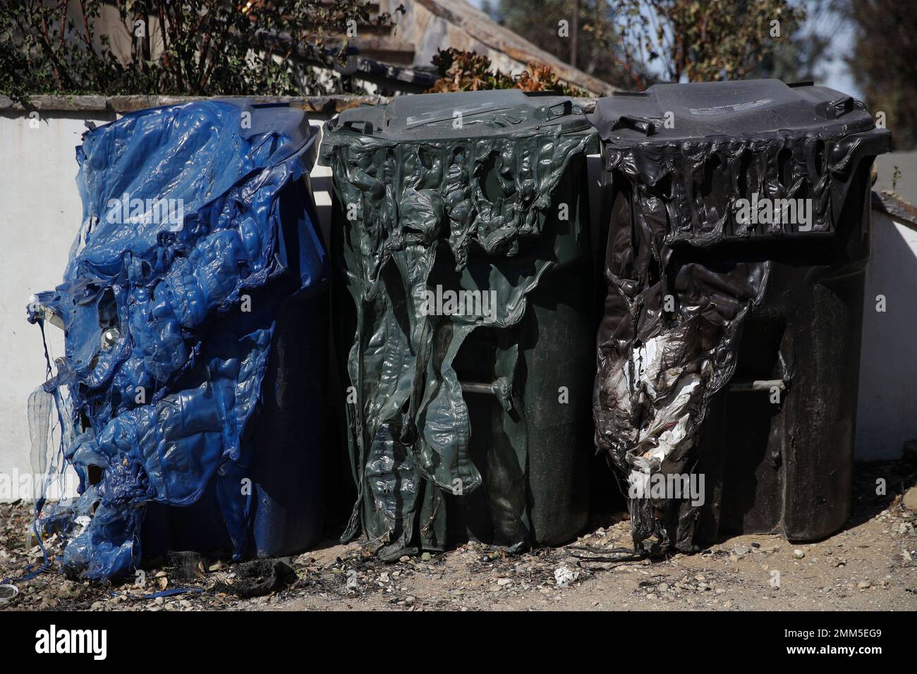 Melted trash bins stand in front of a home burned down by the Woolsey ...
