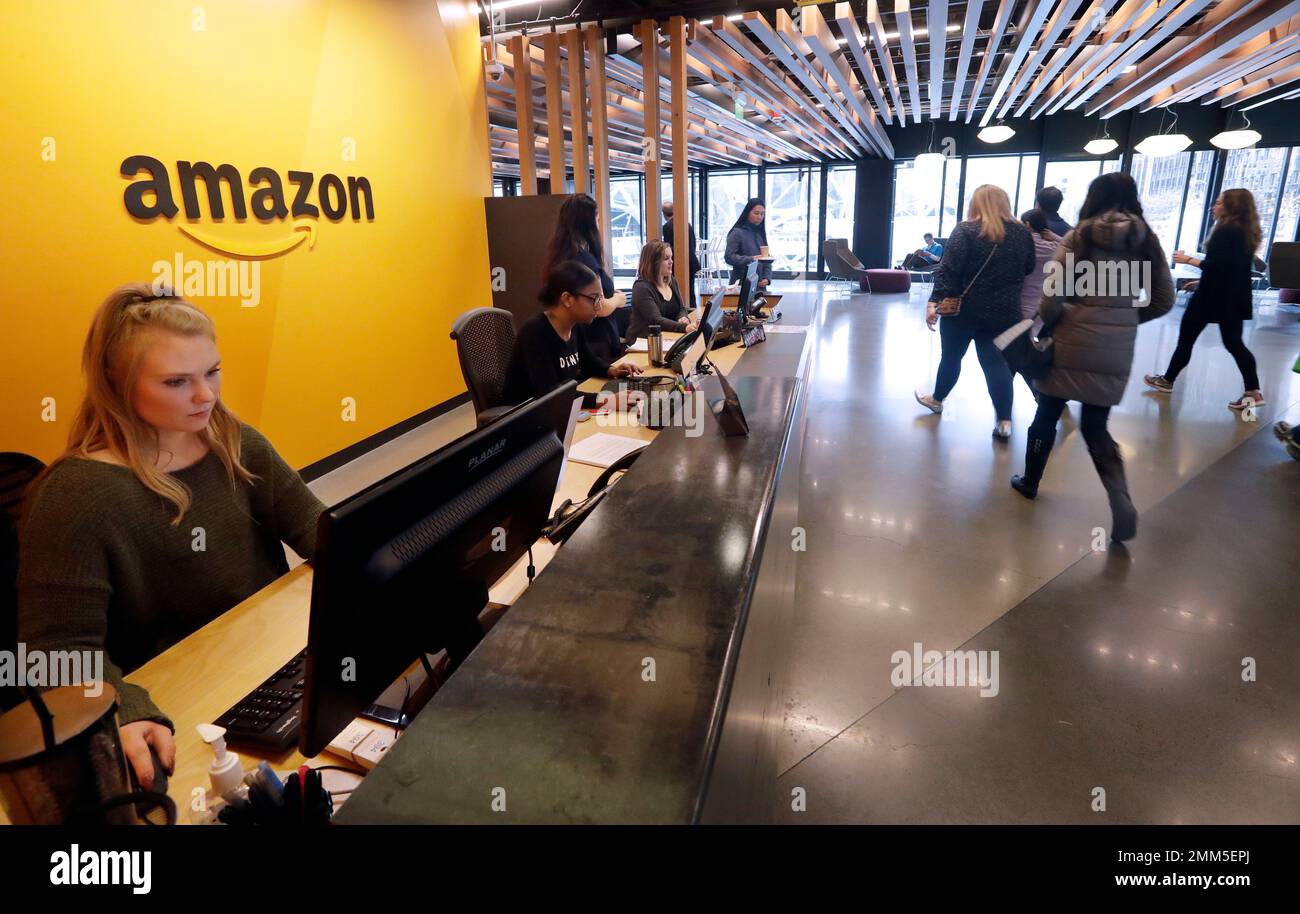 Employees walk through a lobby at Amazon's headquarters Tuesday, Nov ...