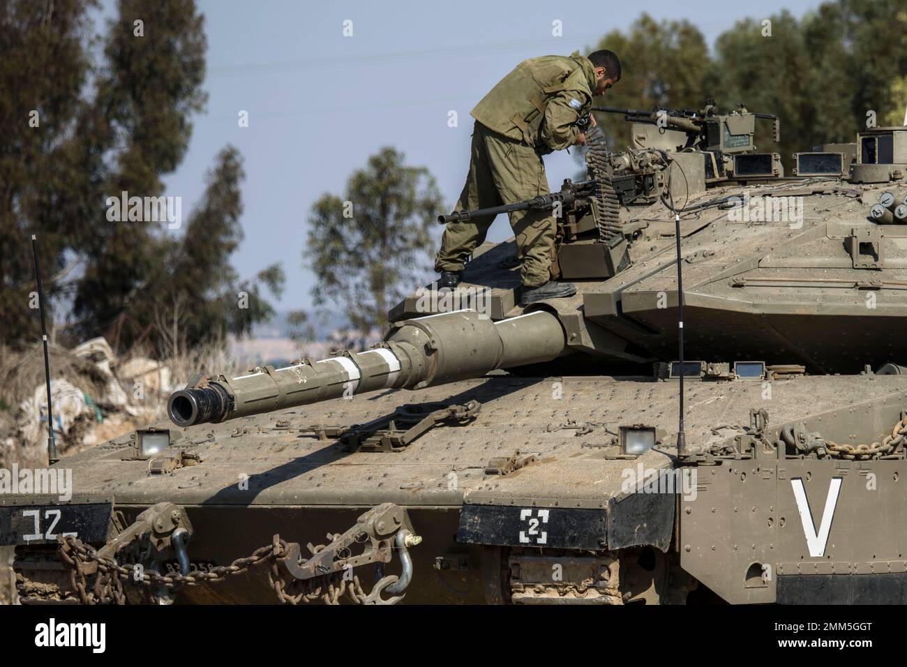 An Israeli soldier stands on a tank near the Israel Gaza border ...