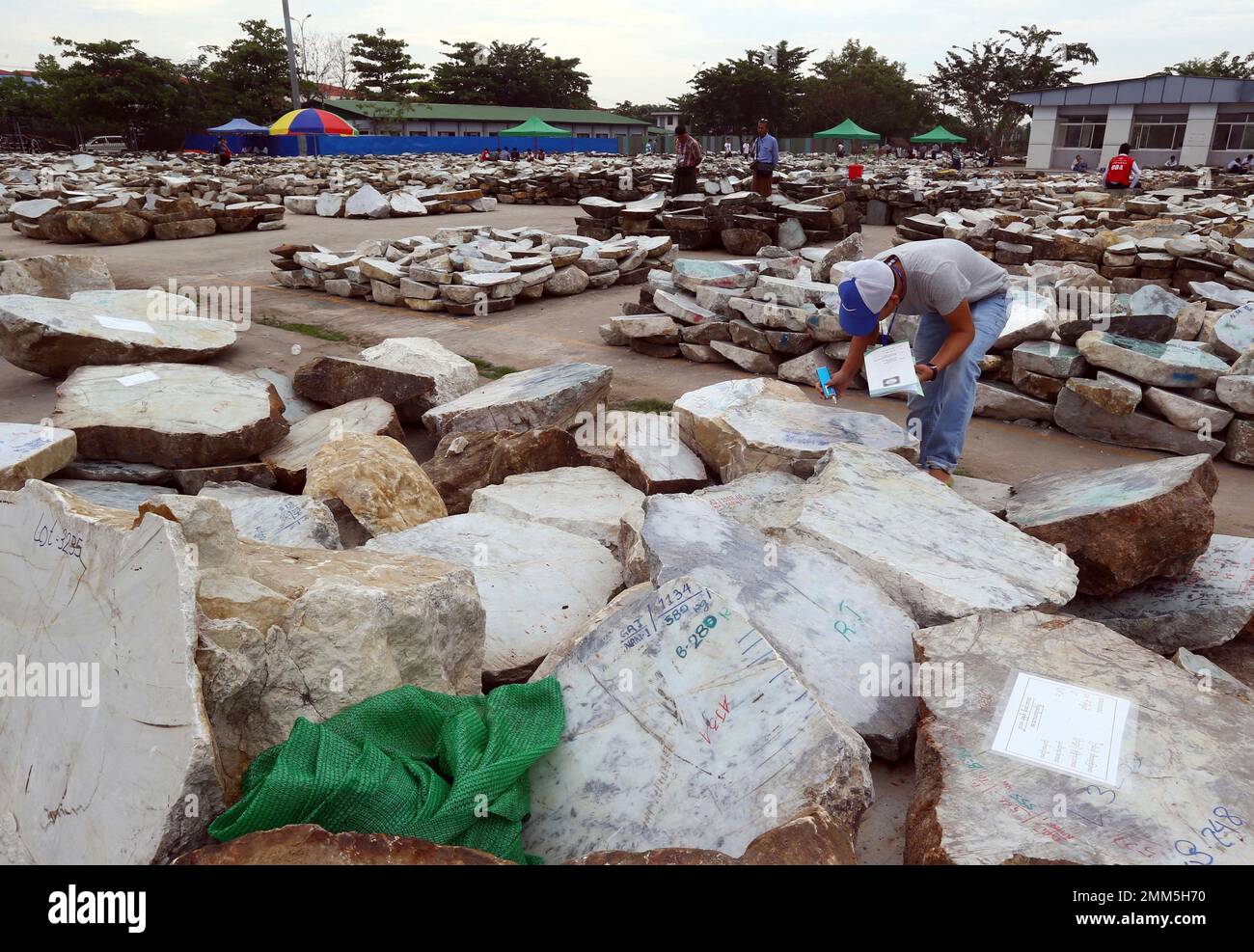 Merchants examine a jade stone displayed at the Gems Emporium in ...