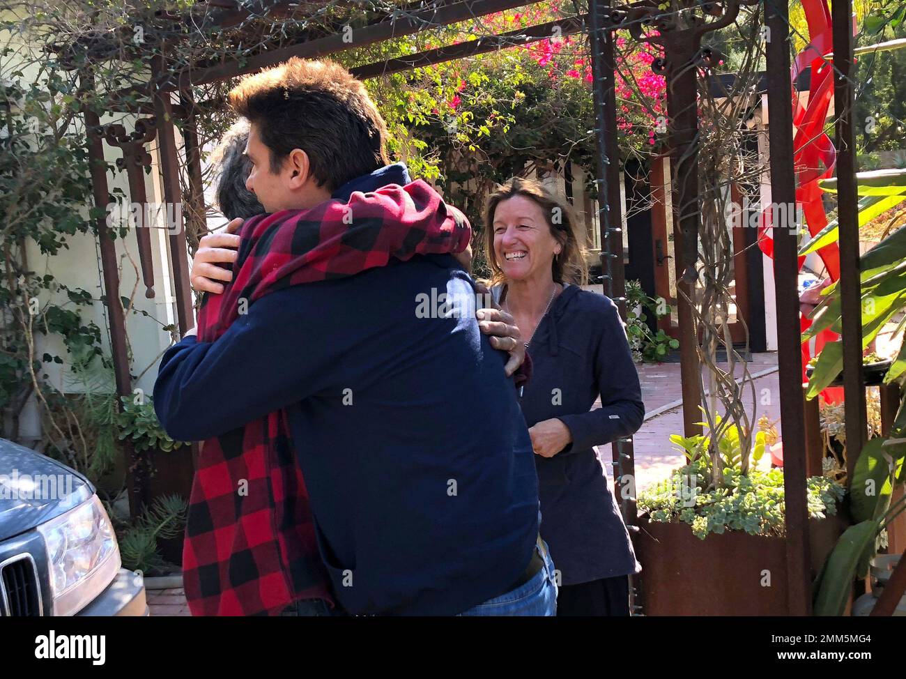 Paul Rasmussen, middle, hugs his neighbor, Randy Berkeley, in the ...