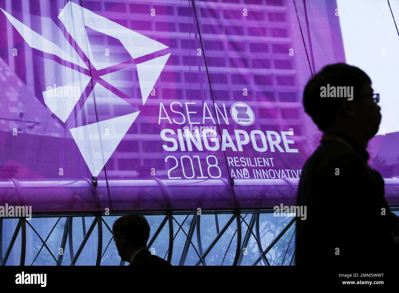 Delegates walk past an event banner at the Suntec Convention Centre ...