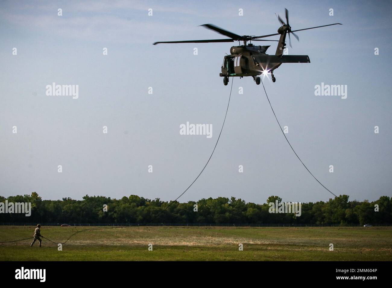 A U.S. Soldier holds a cable as Soldiers and Airmen practice rappelling ...